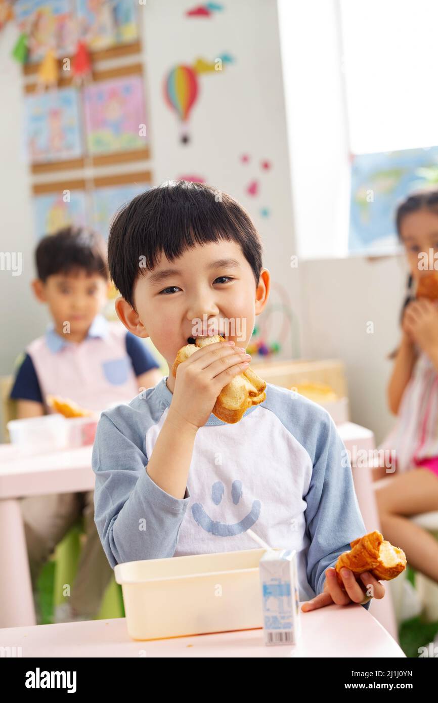 Kindergarten children eat Stock Photo - Alamy