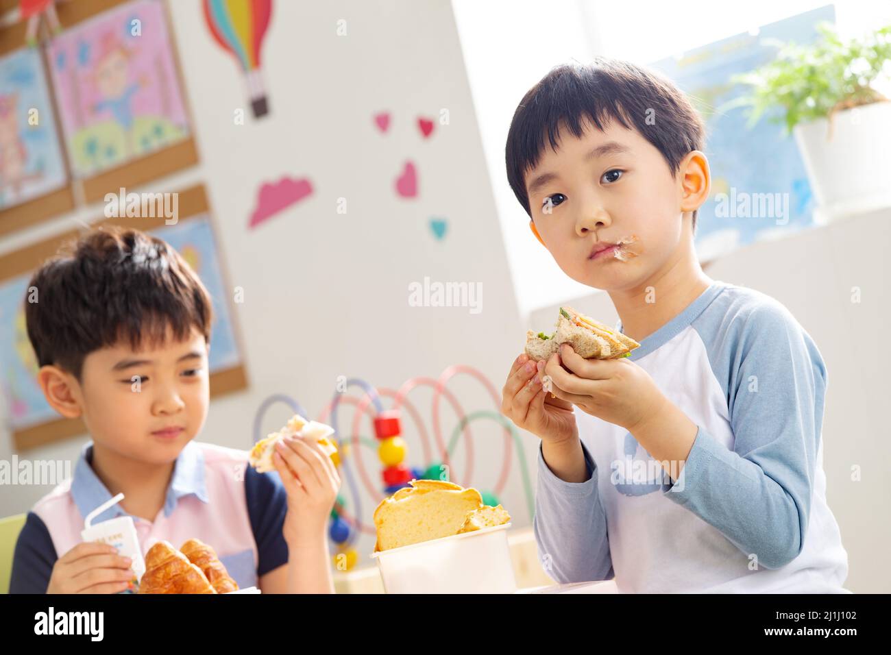 Kindergarten children eat Stock Photo - Alamy