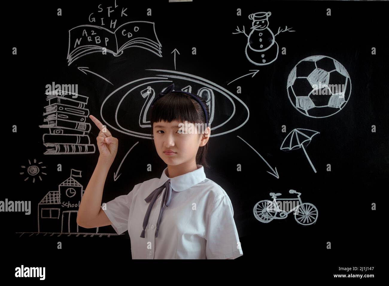 Primary school girl standing in front of the blackboard Stock Photo - Alamy