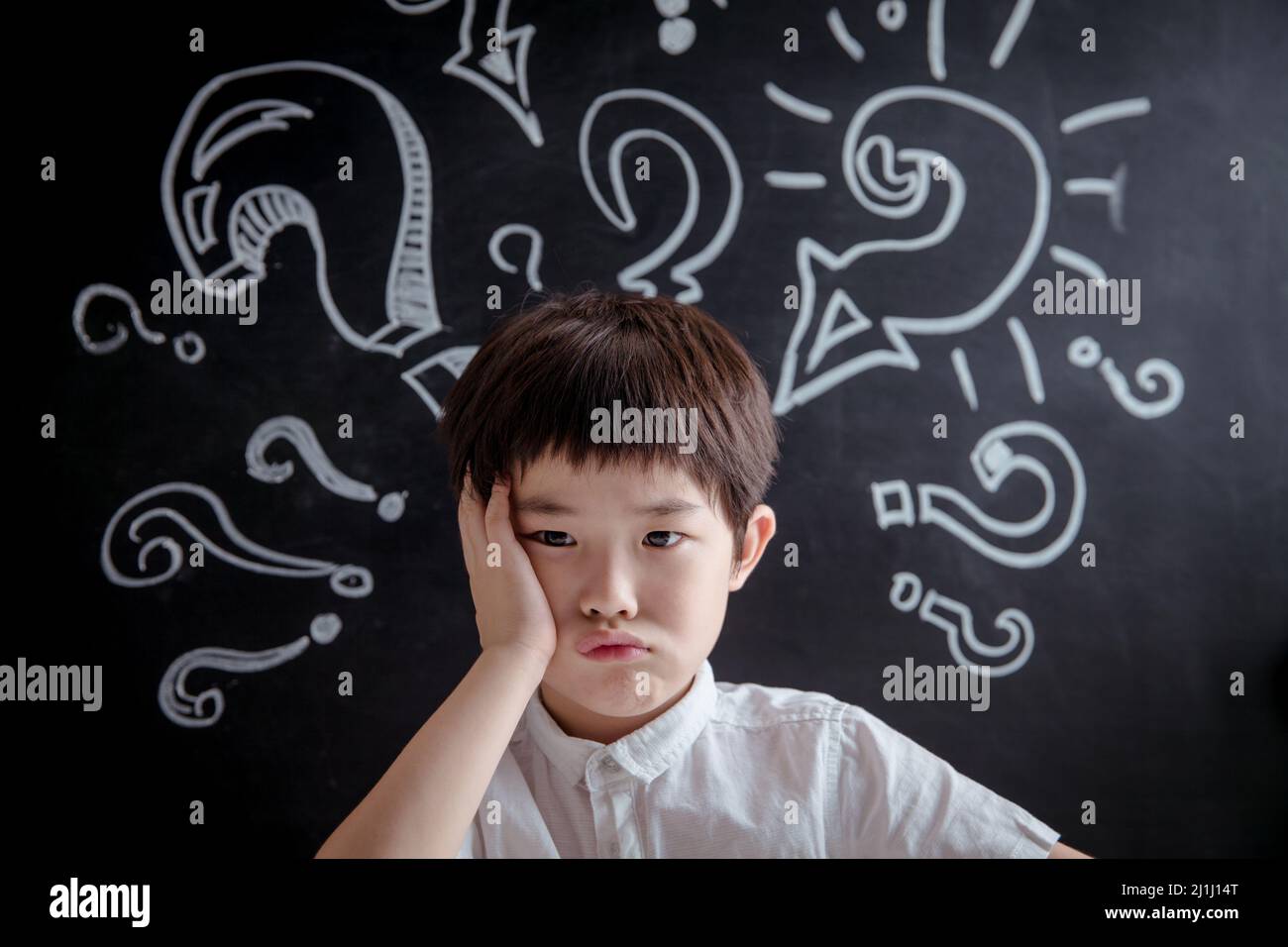 Primary school boy in thinking Stock Photo - Alamy