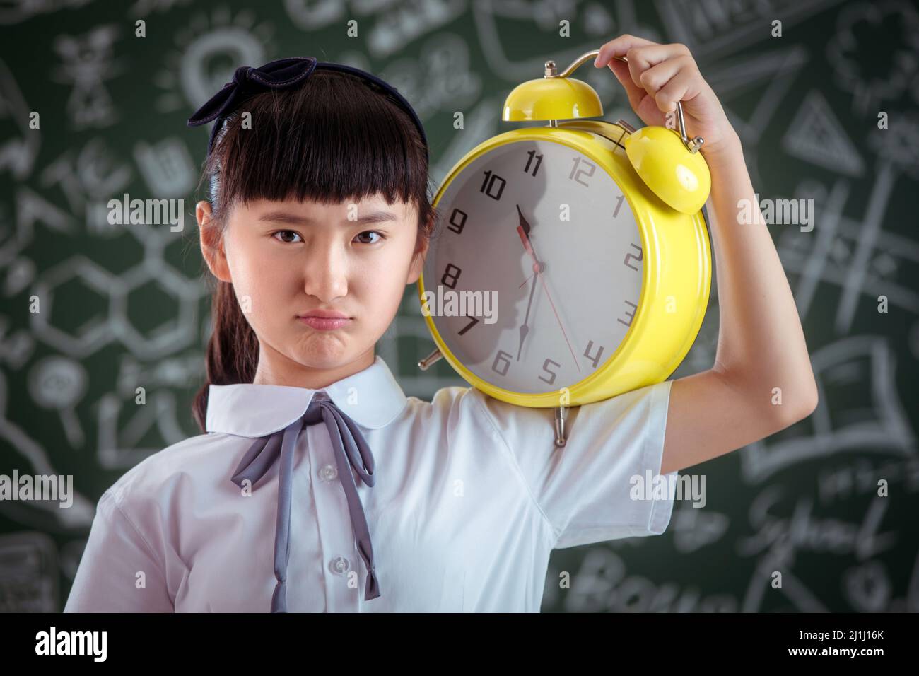 Primary school girls take the alarm clock Stock Photo - Alamy
