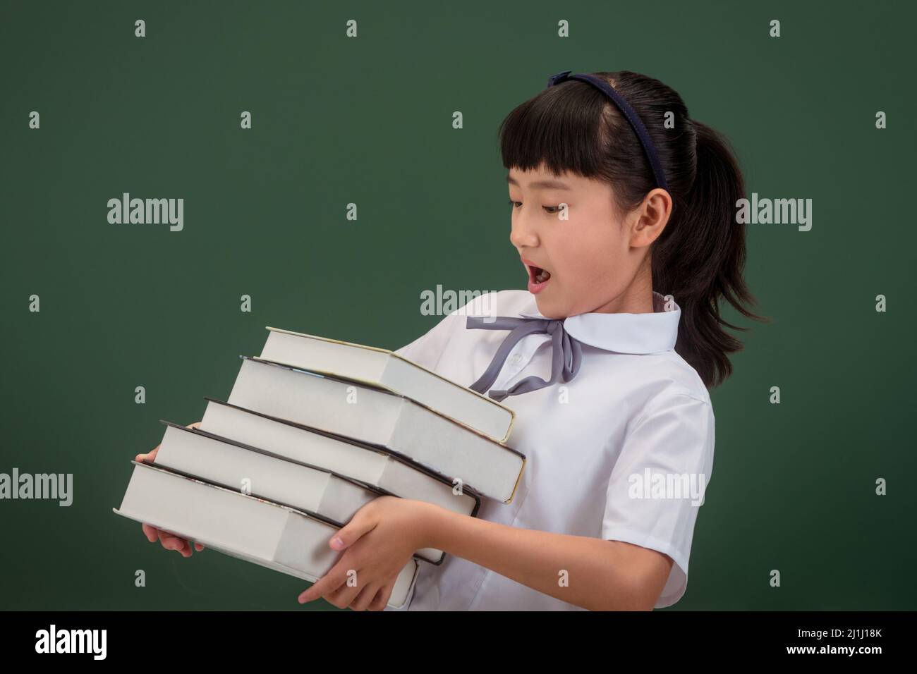 Cute schoolgirl holding books hi-res stock photography and images - Alamy