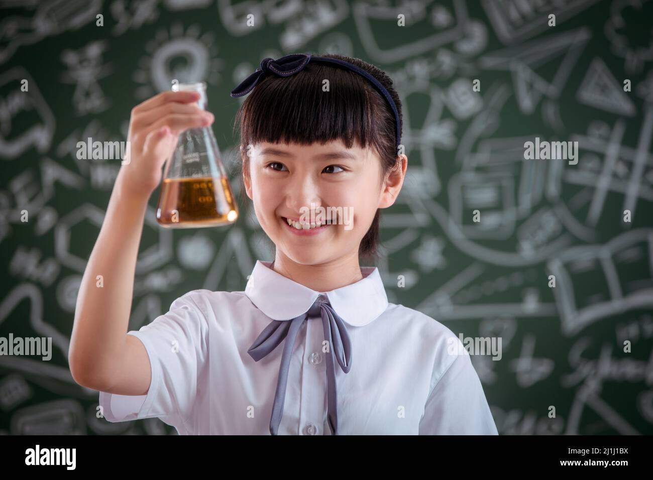 Primary school girls holding a beaker Stock Photo - Alamy