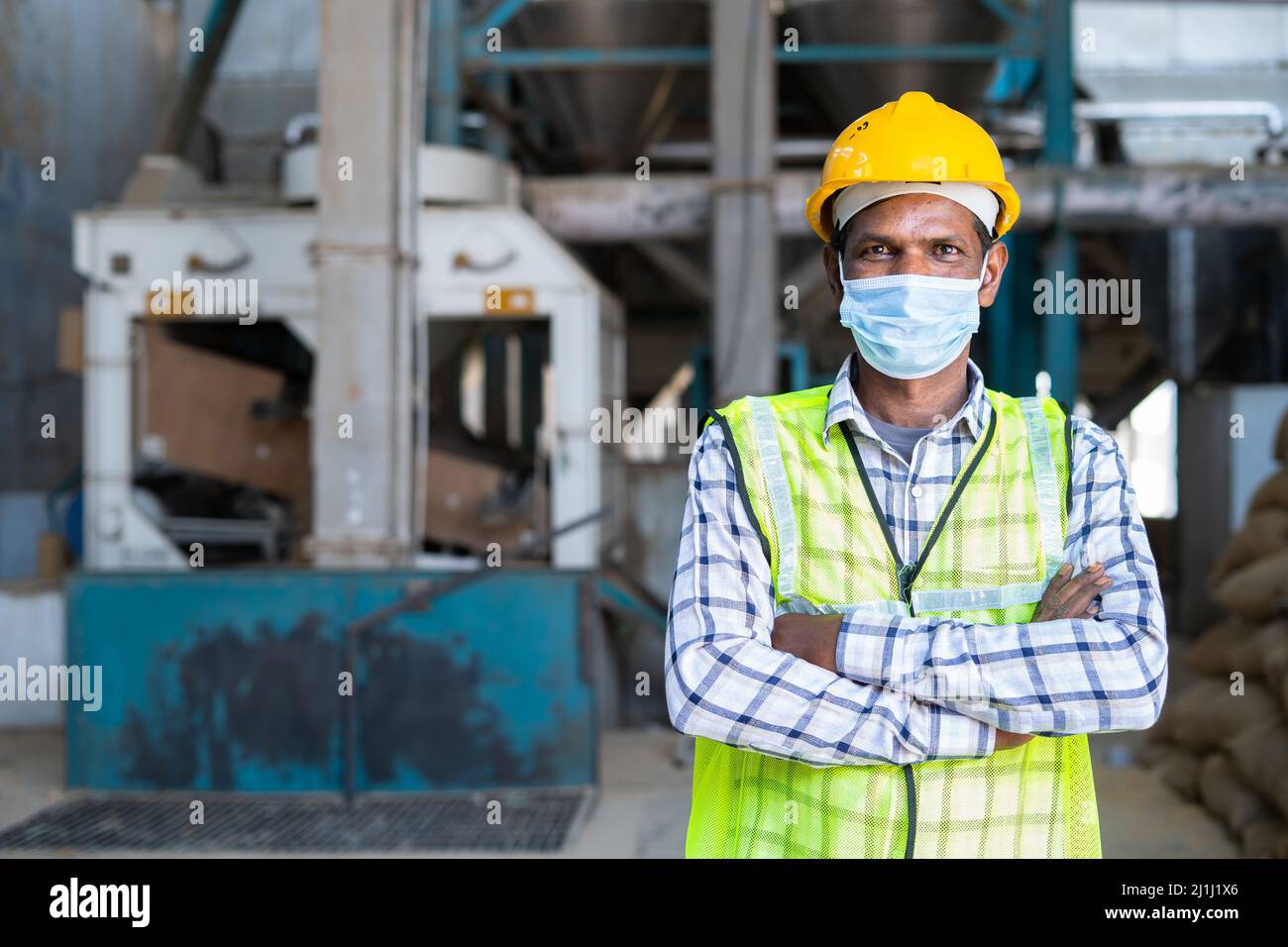 confident Industrial worker standing with medical face mask crossed ...