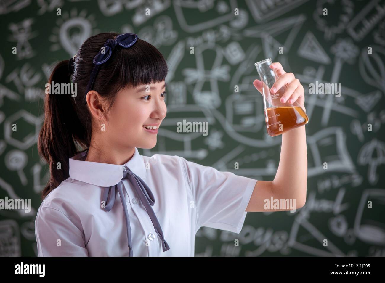 Primary school girls holding a beaker Stock Photo - Alamy