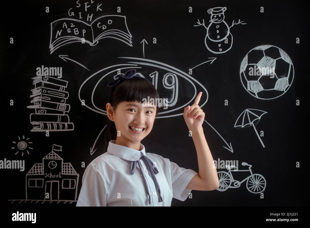 Primary school girl standing in front of the blackboard Stock Photo - Alamy