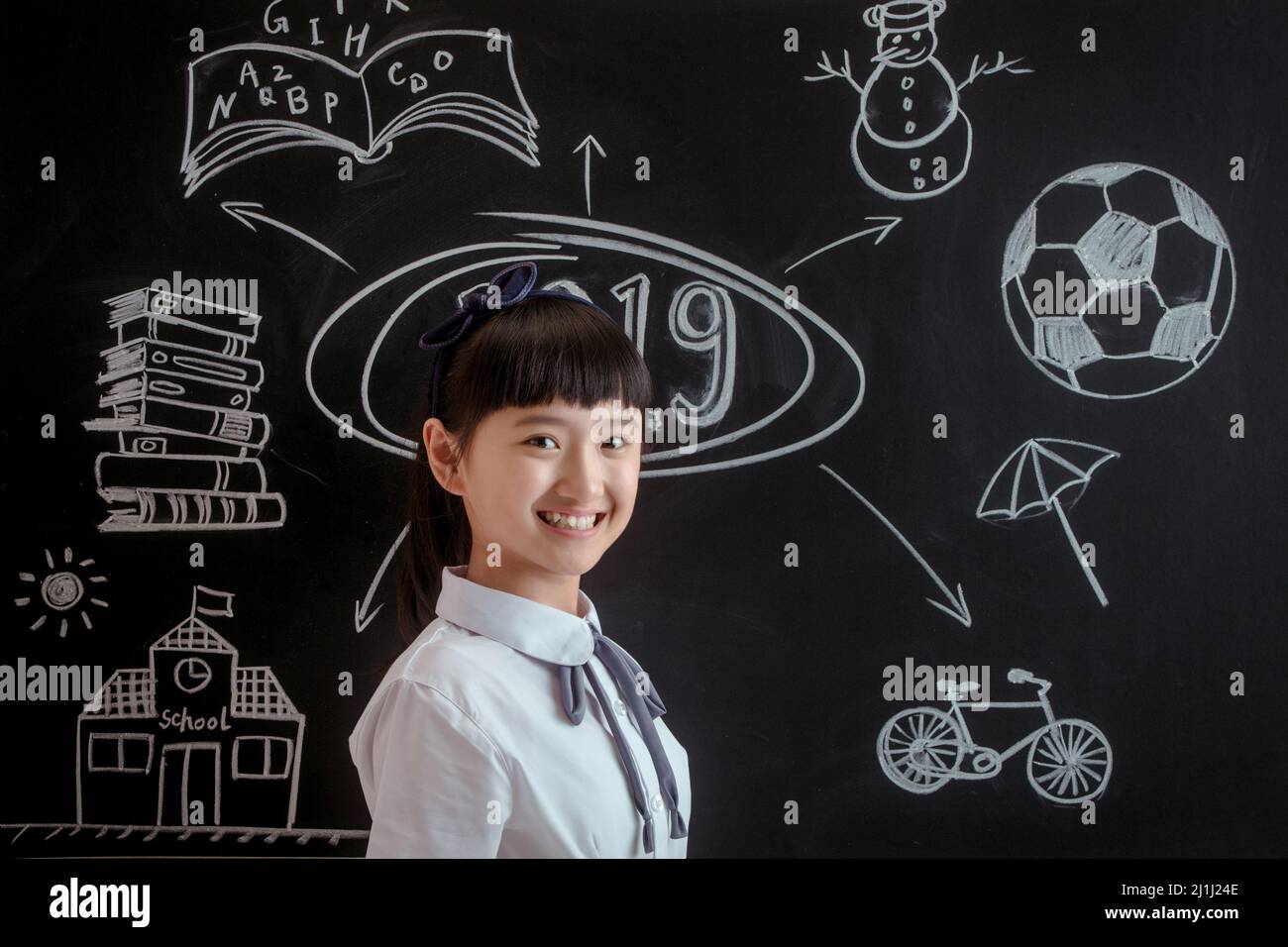 Primary school girl standing in front of the blackboard Stock Photo - Alamy