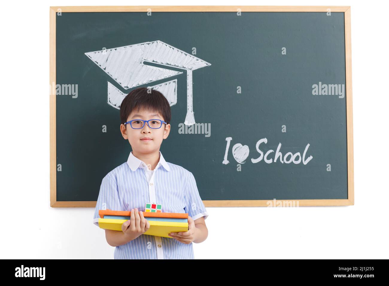 Primary school boy standing in front of the blackboard Stock Photo - Alamy