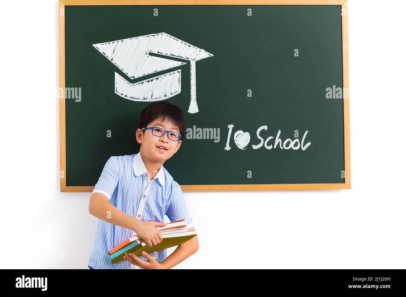 Primary school boy standing in front of the blackboard Stock Photo - Alamy