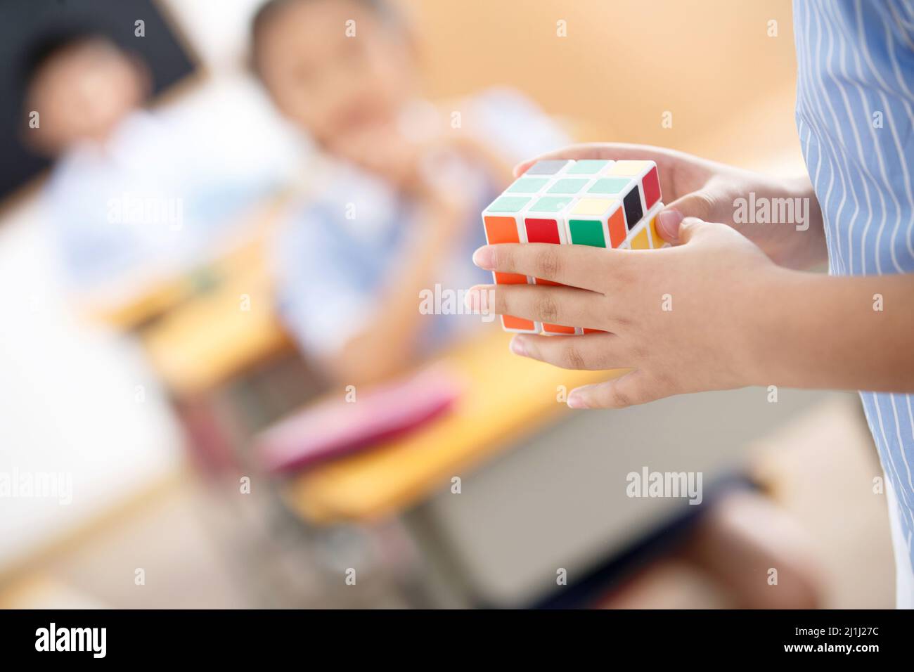 Elementary school students to play rubik's cube Stock Photo - Alamy