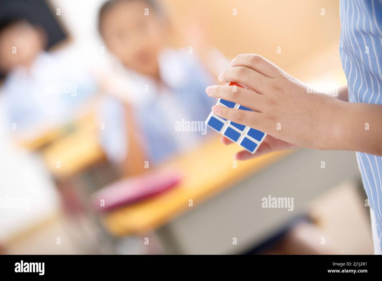 Elementary school students to play rubik's cube Stock Photo - Alamy