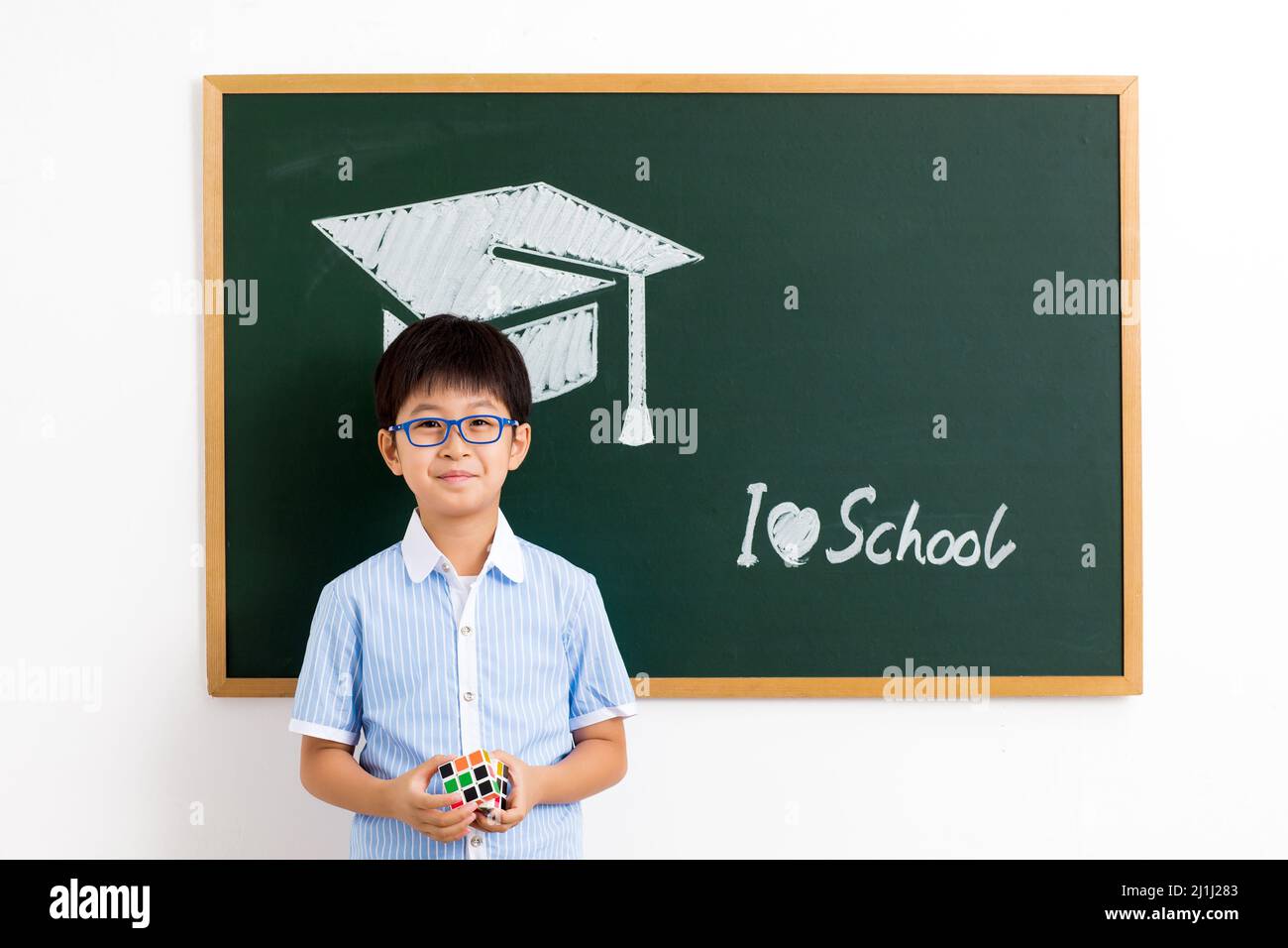 Primary school boy standing in front of the blackboard Stock Photo - Alamy