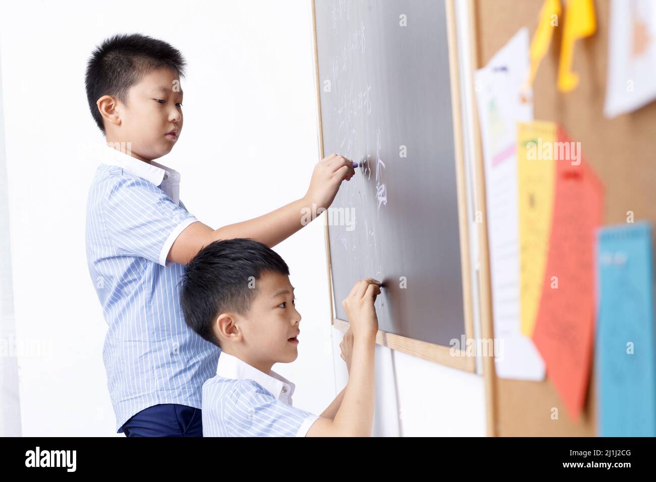 Primary school boys are writing on the blackboard Stock Photo - Alamy