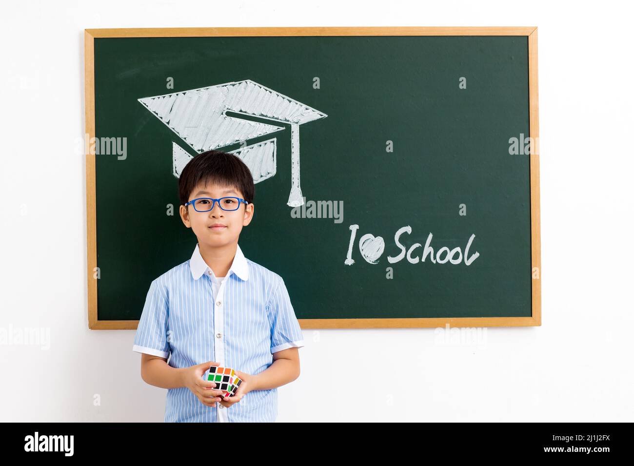 Primary school boy standing in front of the blackboard Stock Photo - Alamy