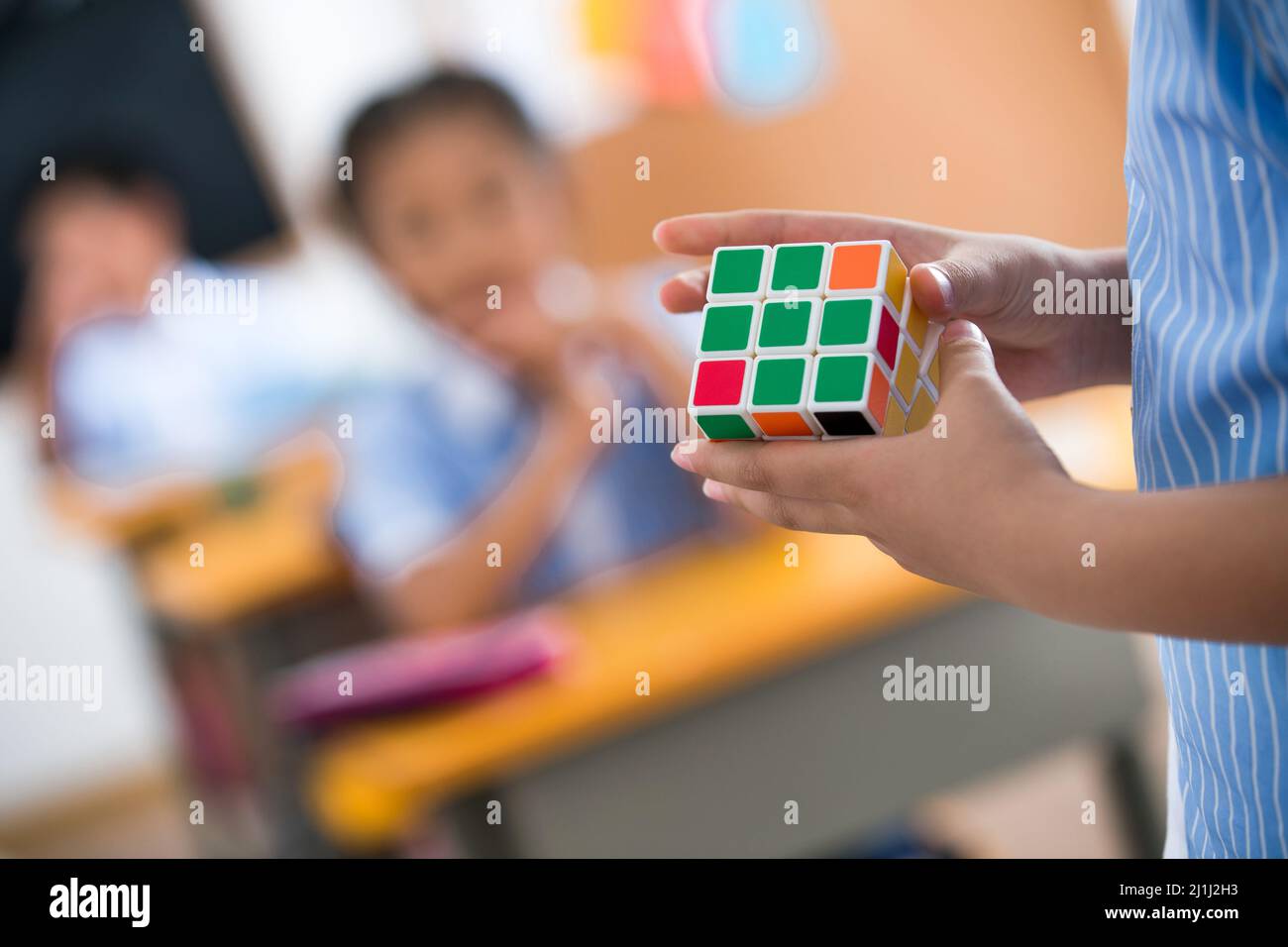 Elementary school students to play rubik's cube Stock Photo - Alamy