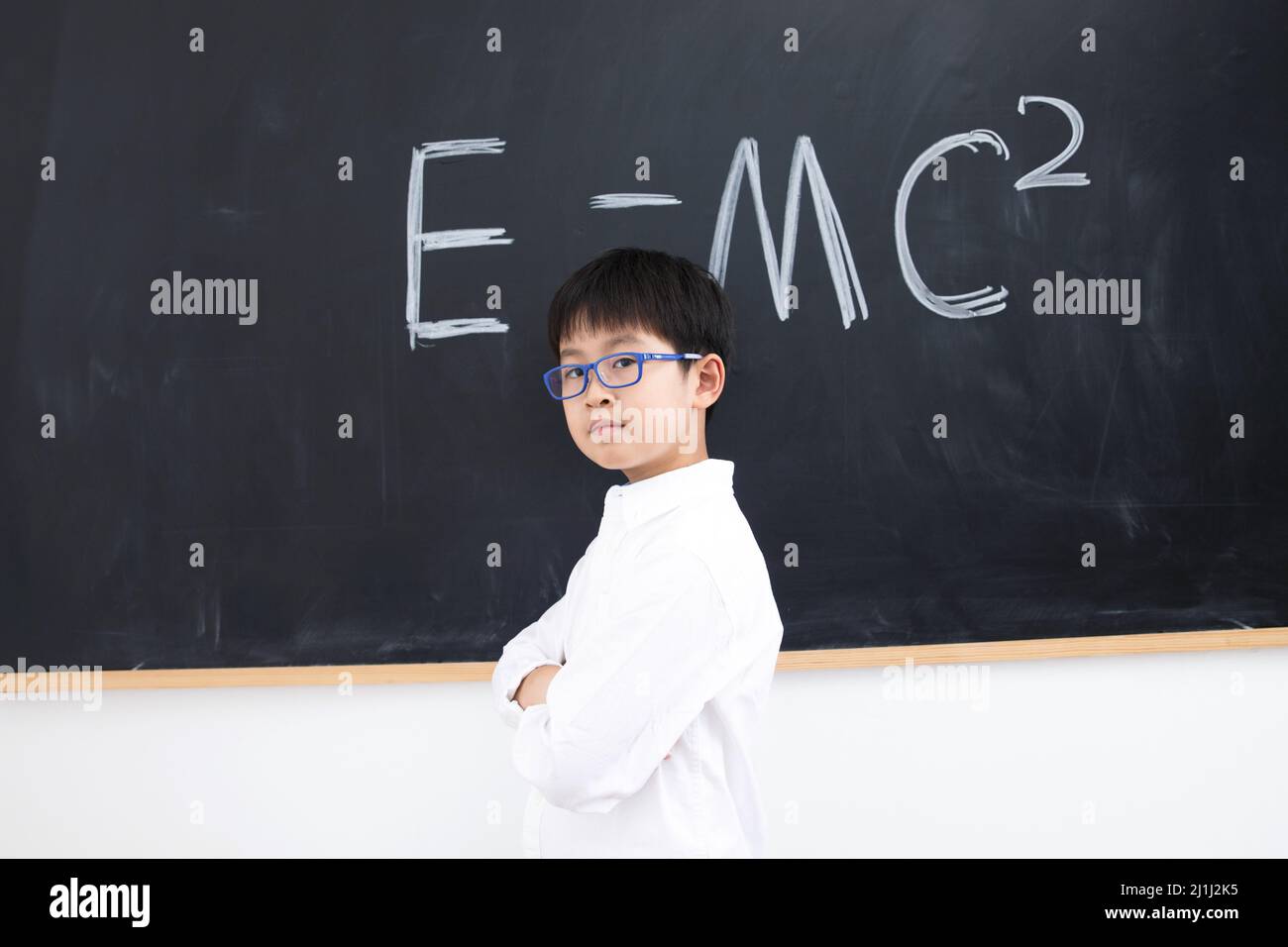 Primary school boy standing in front of the blackboard Stock Photo - Alamy