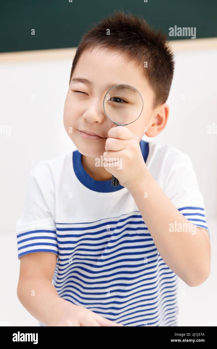 Primary school boys with a magnifying glass Stock Photo - Alamy