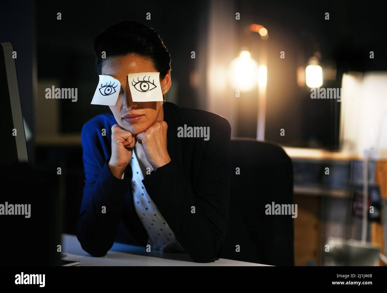 Half asleep, half awake. Shot of a young businesswoman working late in ...