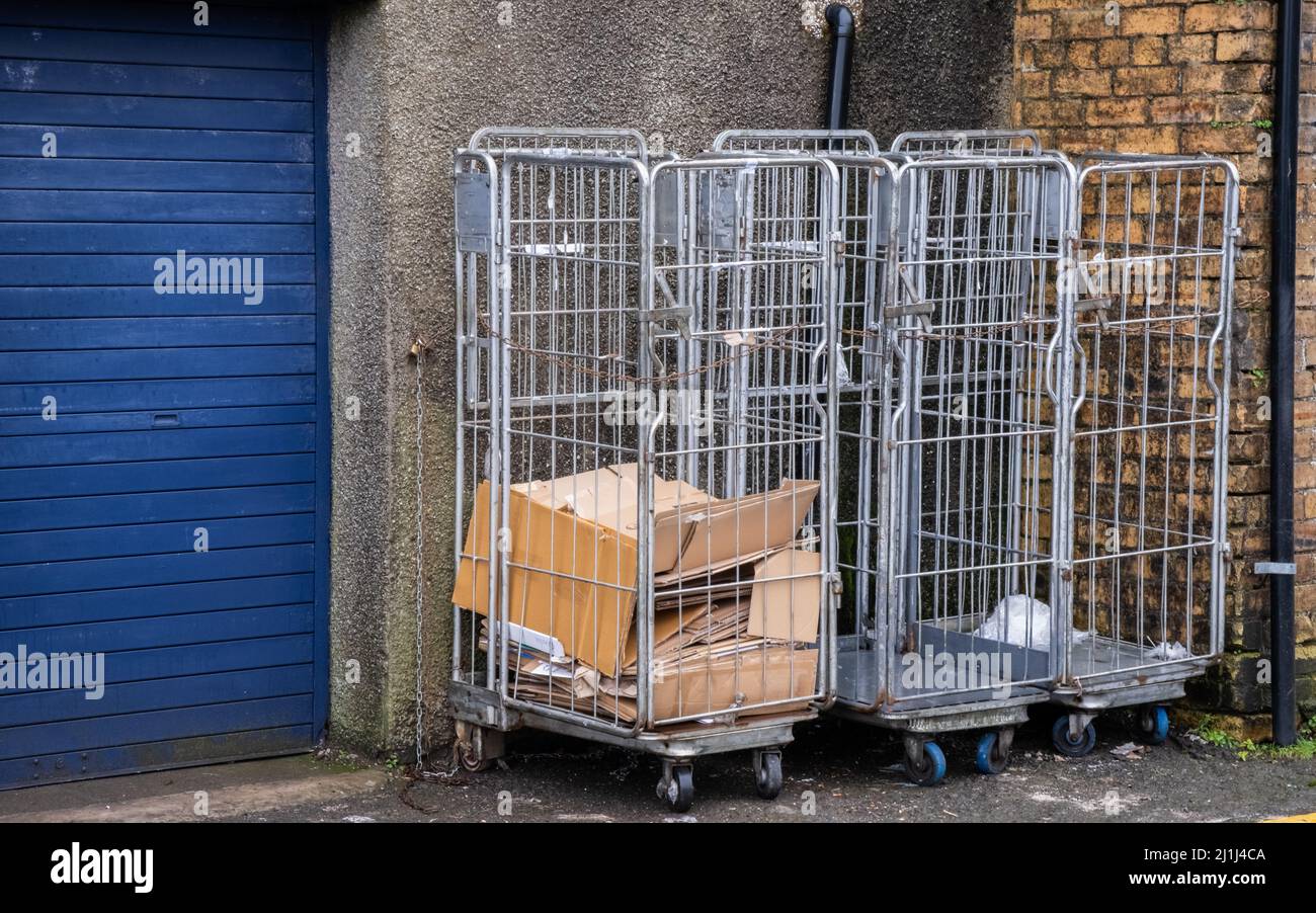 Cardboard trash collected in trolley roll cage at the back of a shop ...
