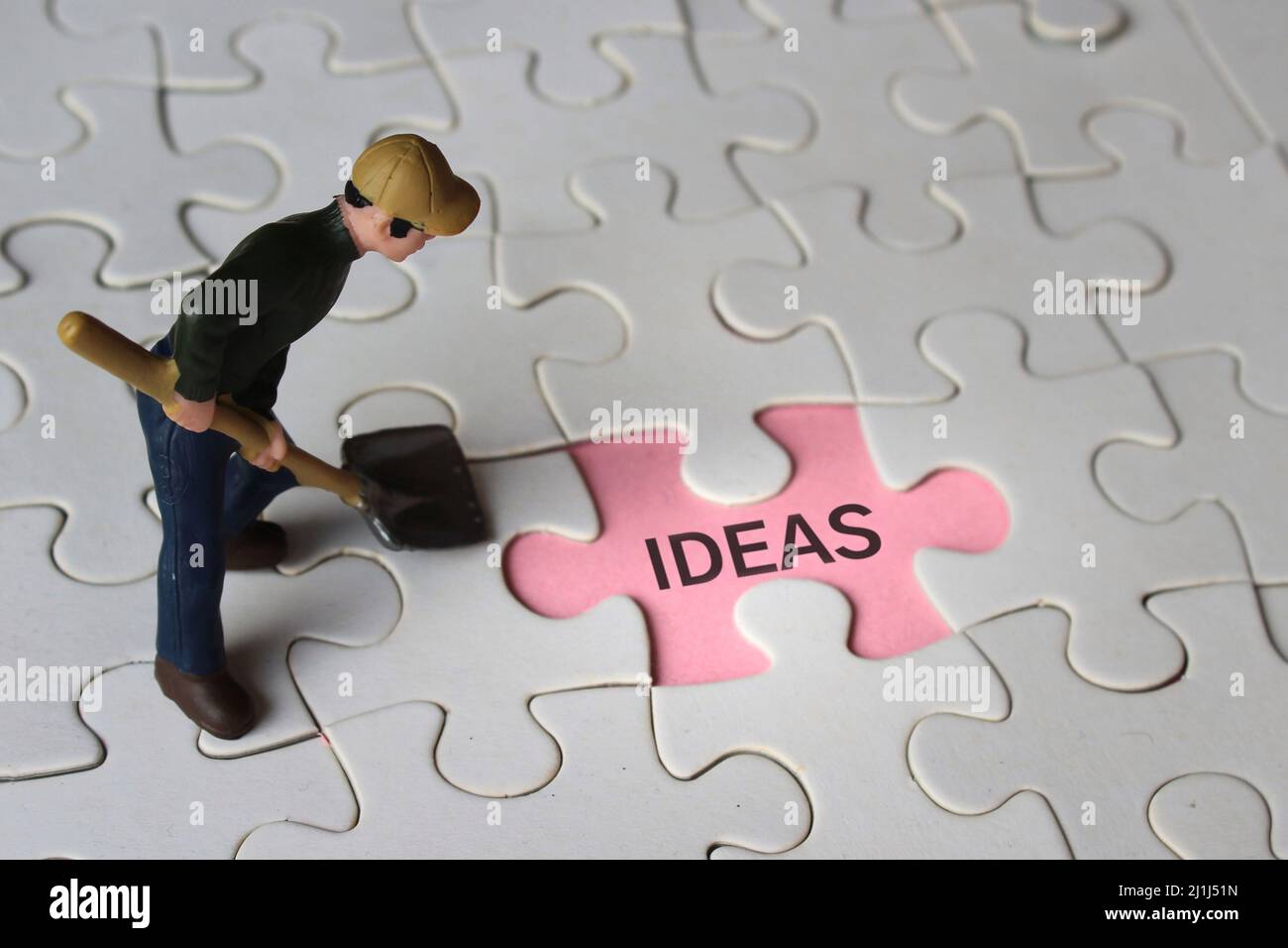 Miniature man and missing jigsaw puzzle with text IDEAS. Looking for ...