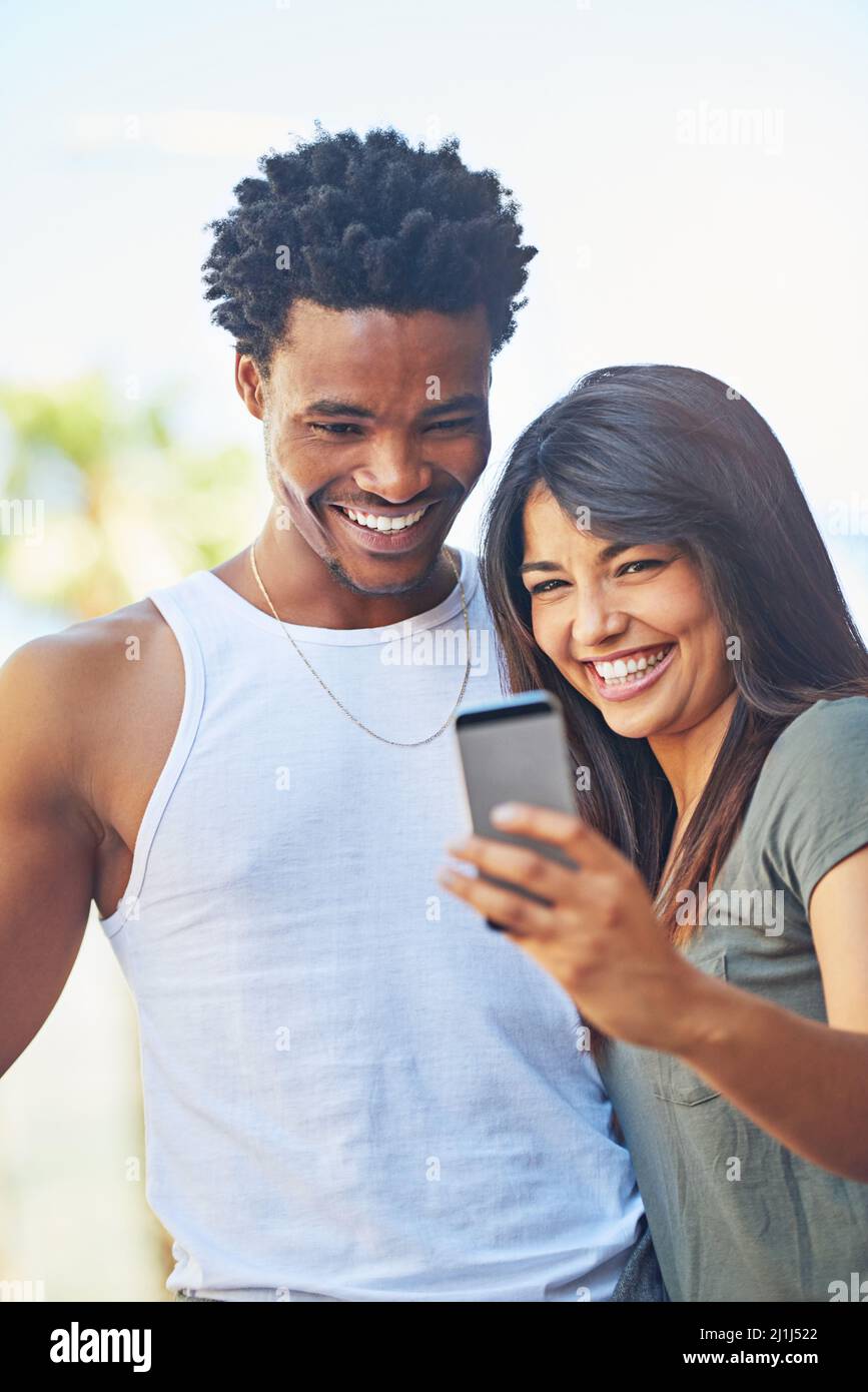 Couple profile pic. Shot of a happy young couple using a mobile phone ...