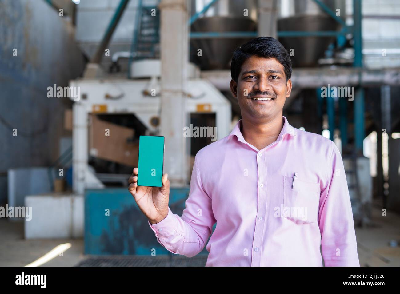 supervisor showing green screen mobile phone while looking at camera at ...