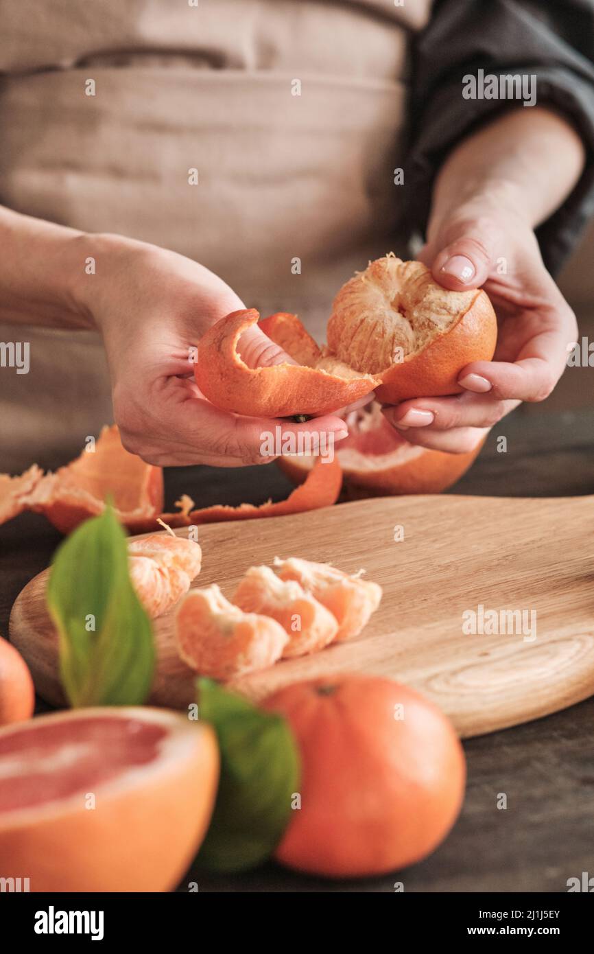 Close-up of unrecognizable woman standing at kitchen counter and ...