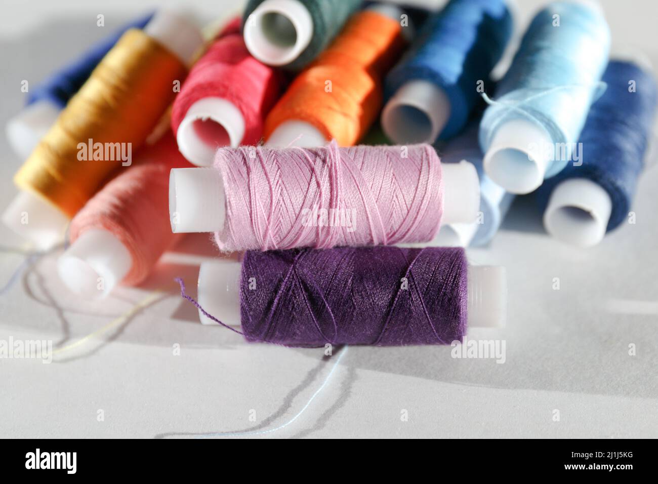 Color thread. Plastic reels with multicolored threads on a white ...