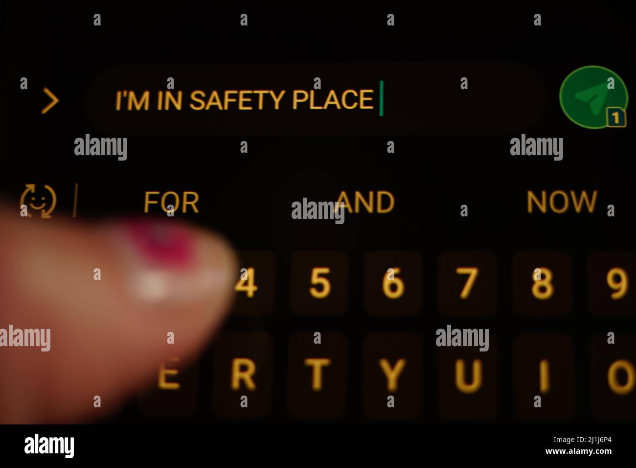 Hand typing question I'M IN SAFETY PLACE, message on black smartphone ...