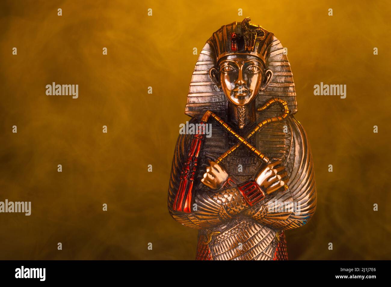 Egyptian pharaoh figurine in orange smoke on a black background. High ...