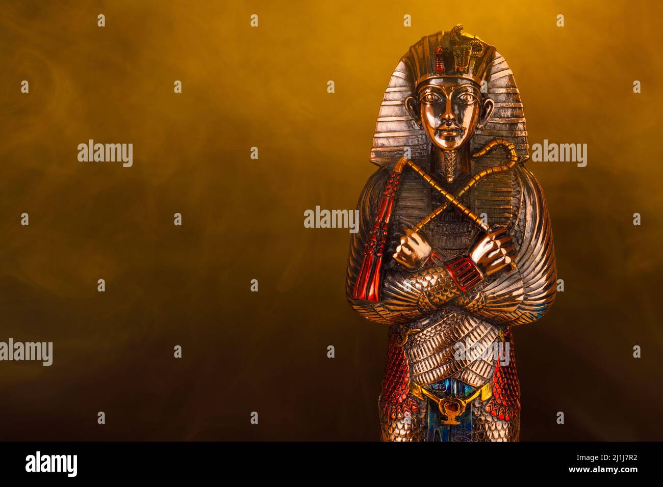 Egyptian pharaoh figurine in orange smoke on a black background. High ...