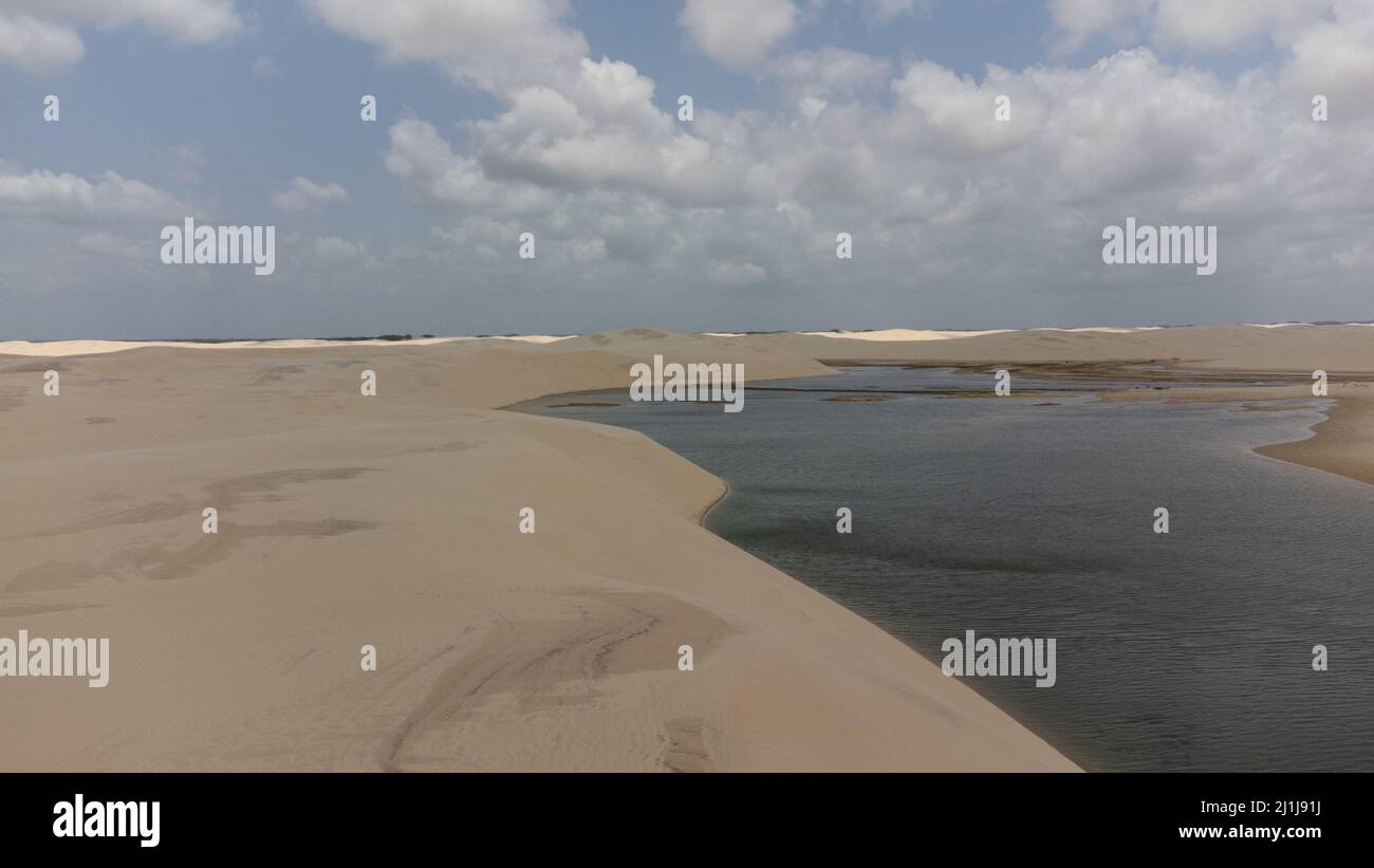 A river flowing through the sandy landscape in Lencois Maranhenses ...