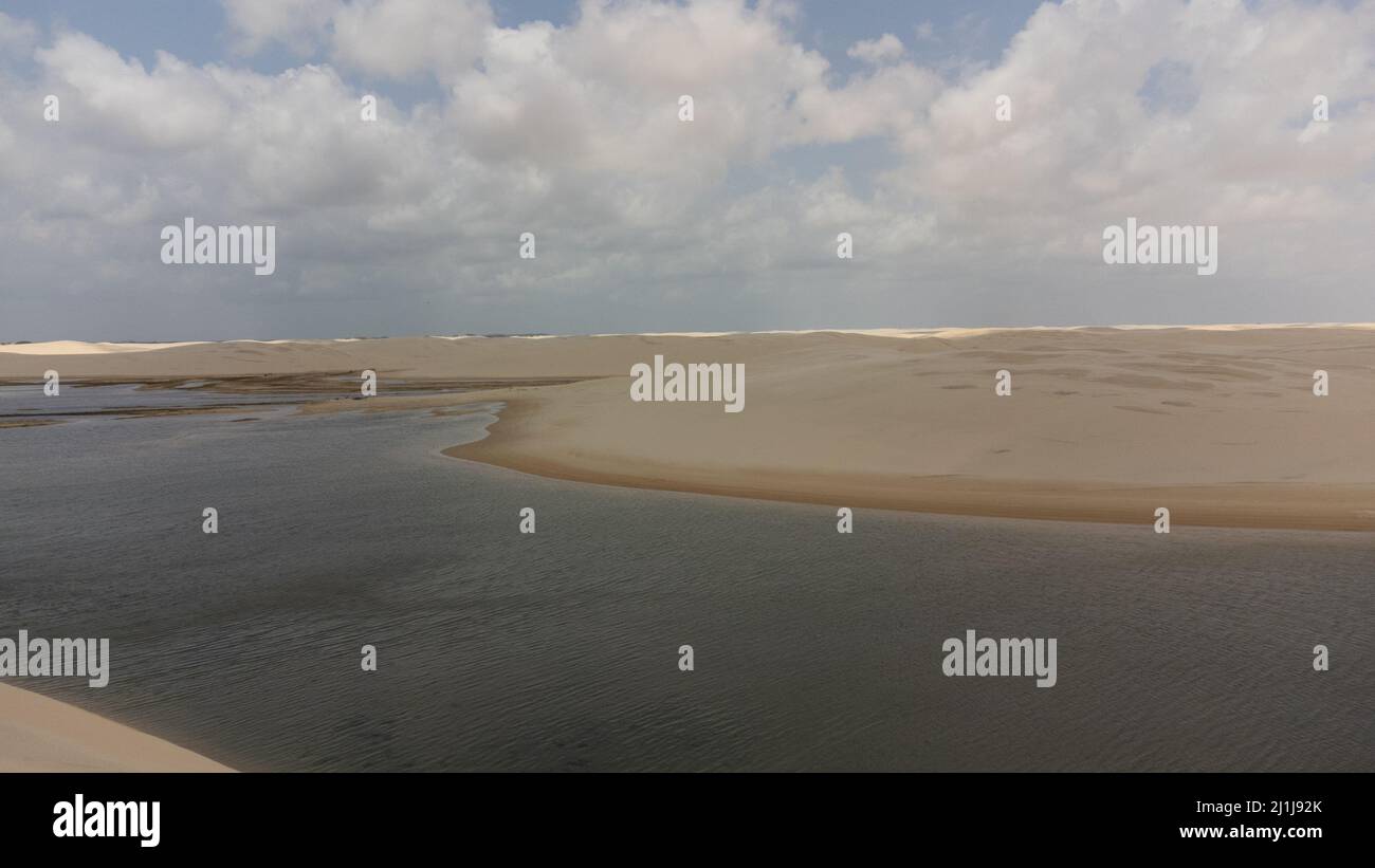A river flowing through the sandy landscape in Lencois Maranhenses ...