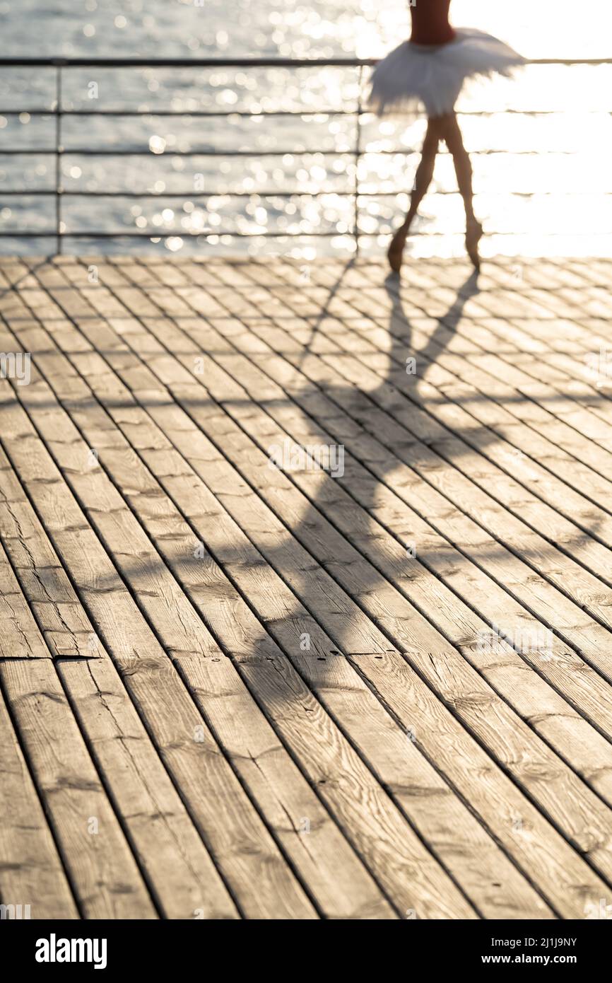 Shadow of blurred female ballet dancer on sunny wood pier Stock Photo ...