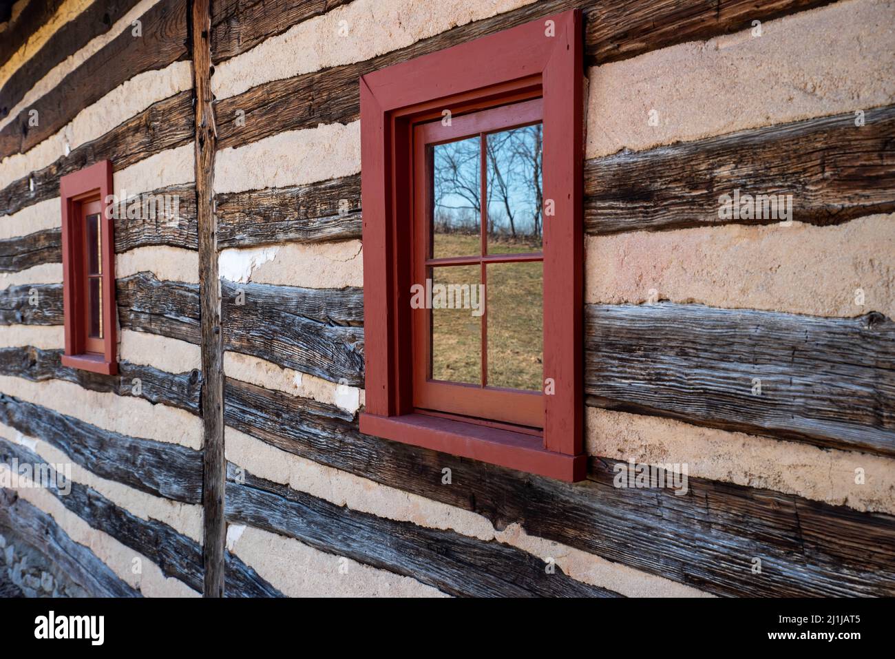 Exterior wall of colonial log cabin landscape reflected in window Stock ...