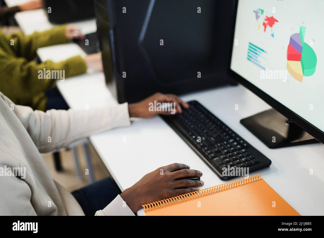 Hands view of young african student using computer inside college room ...