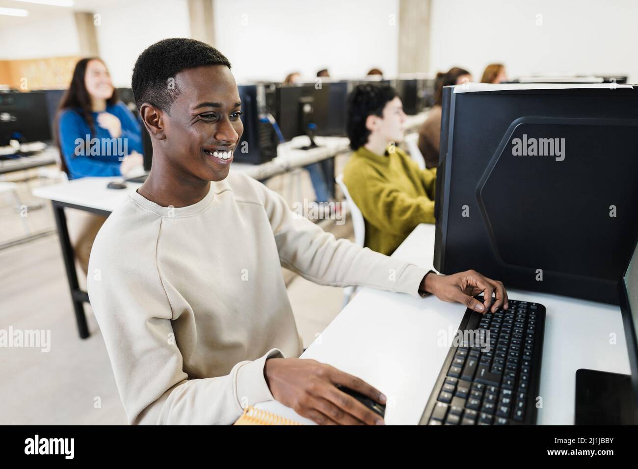 Young african student using computer inside college room at school ...