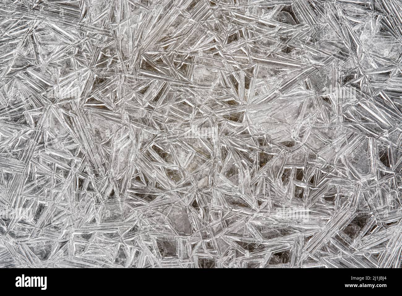 Ice on frozen river forming crystal like structures, closeup macro ...