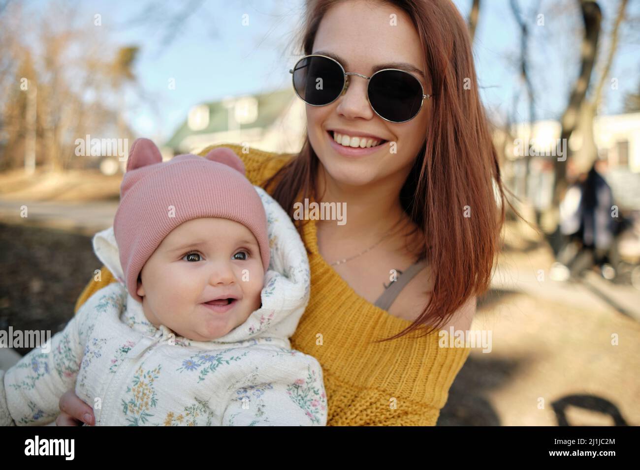 Mother holding baby smiling to camera. Real life authentic casual mom ...