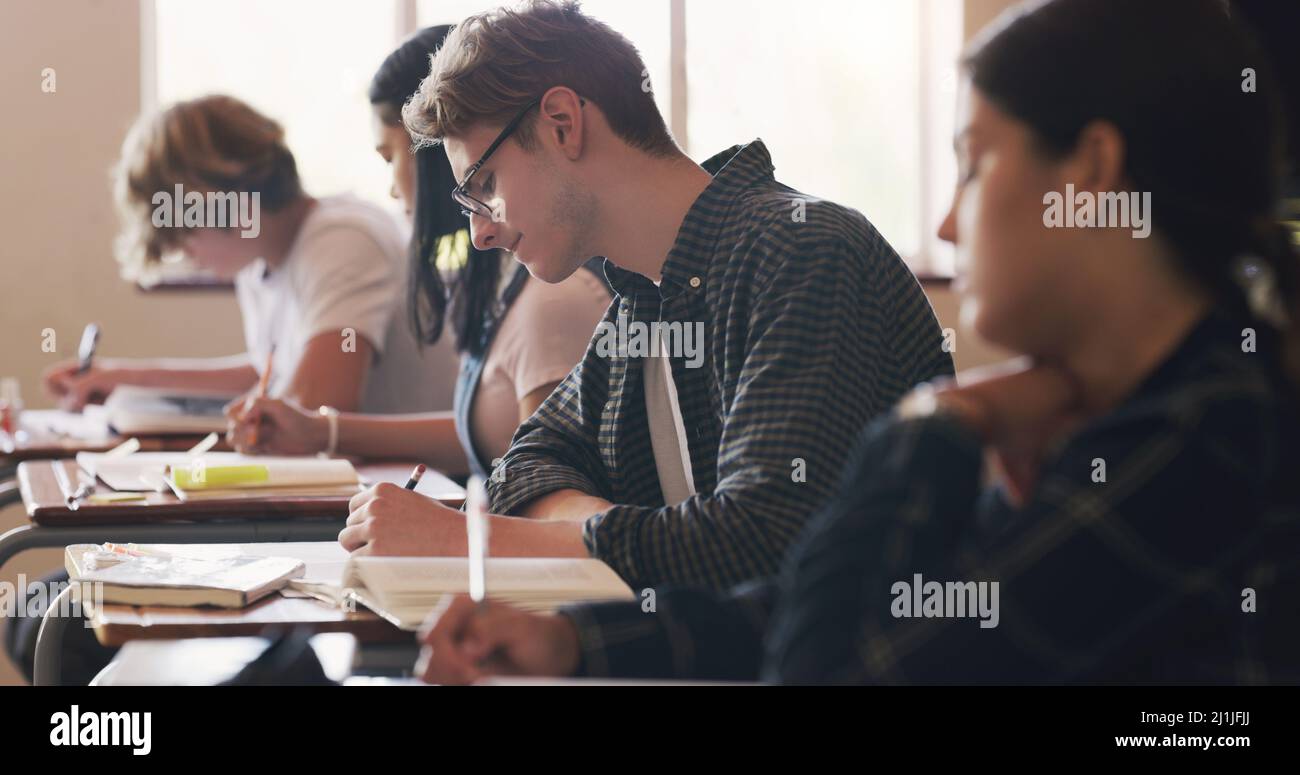 An A+ coming right up. Shot of teenagers writing an exam in a classroom ...