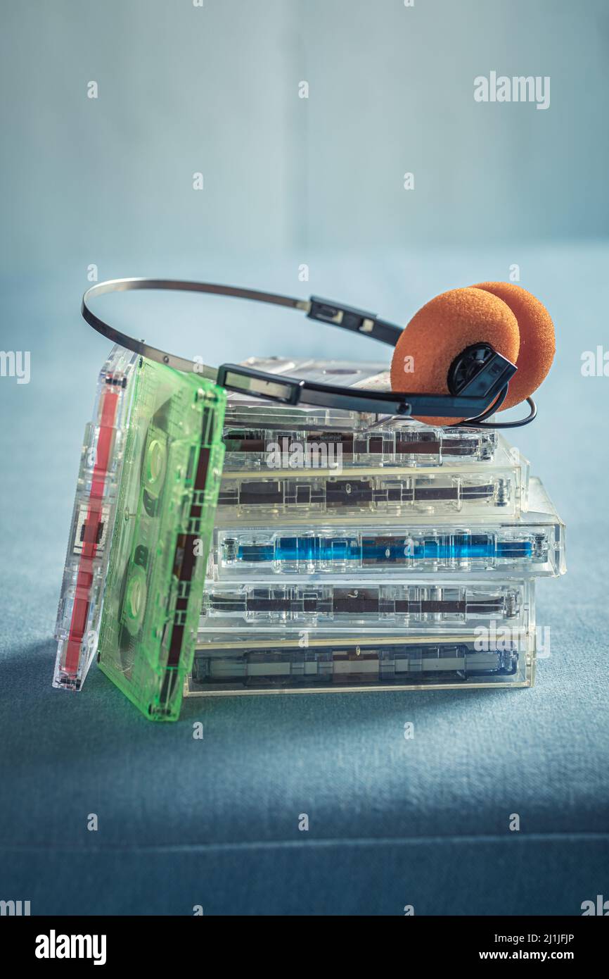 Pile of cassette tapes with orange headphones. Cassette audio tapes ...