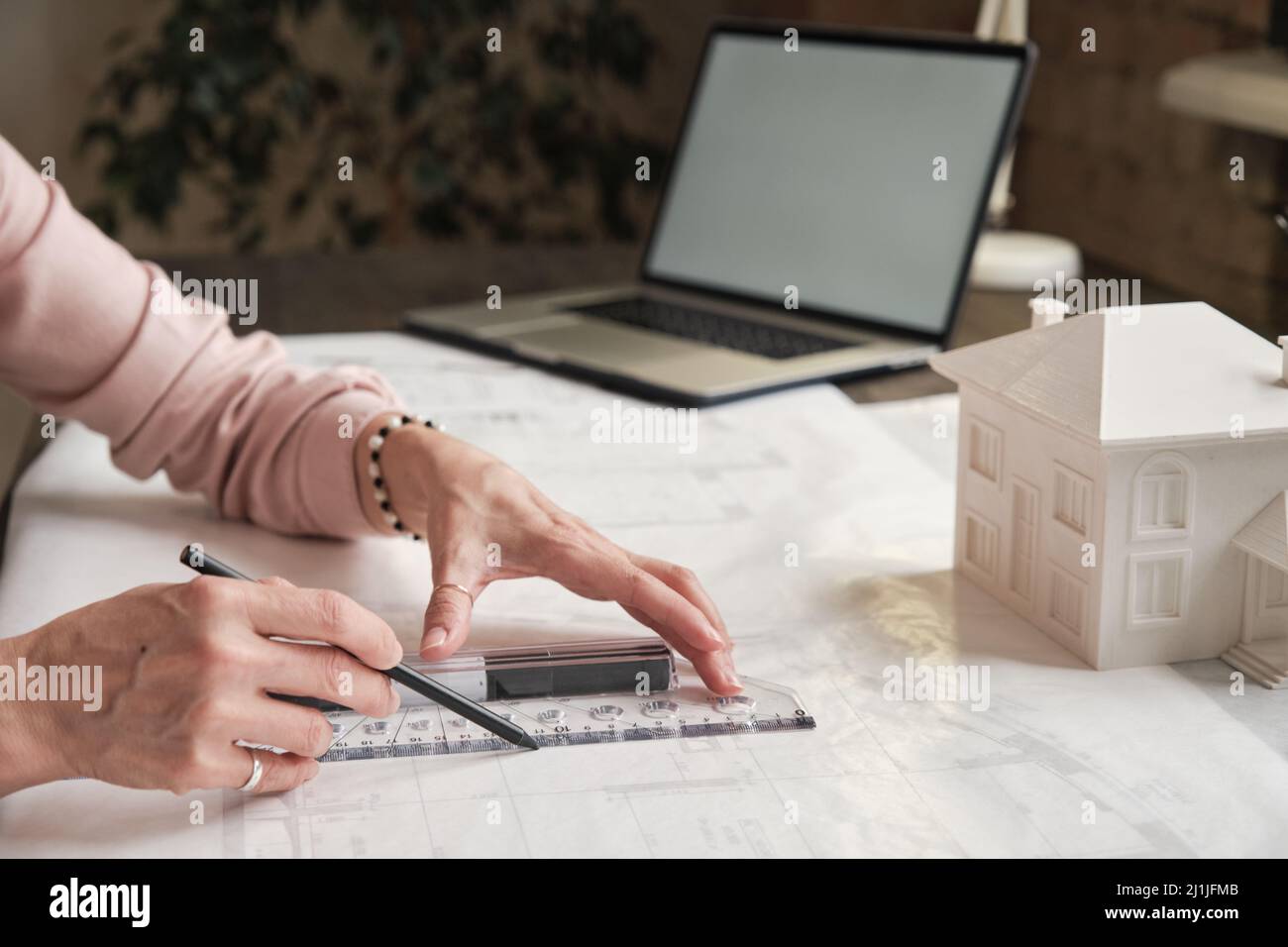 Close-up of unrecognizable female architectural drafter in ring using ...