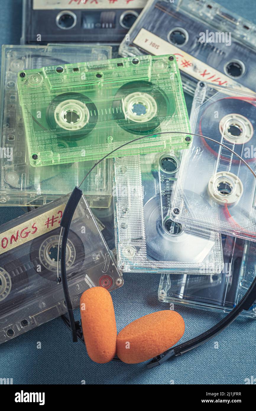 Stack of transparent audio cassettes with orange headphones. Cassette ...
