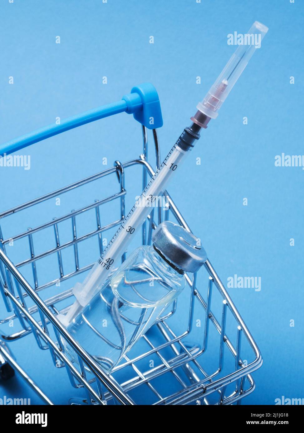 Basket with a syringe and an ampoule on a blue background Stock Photo ...