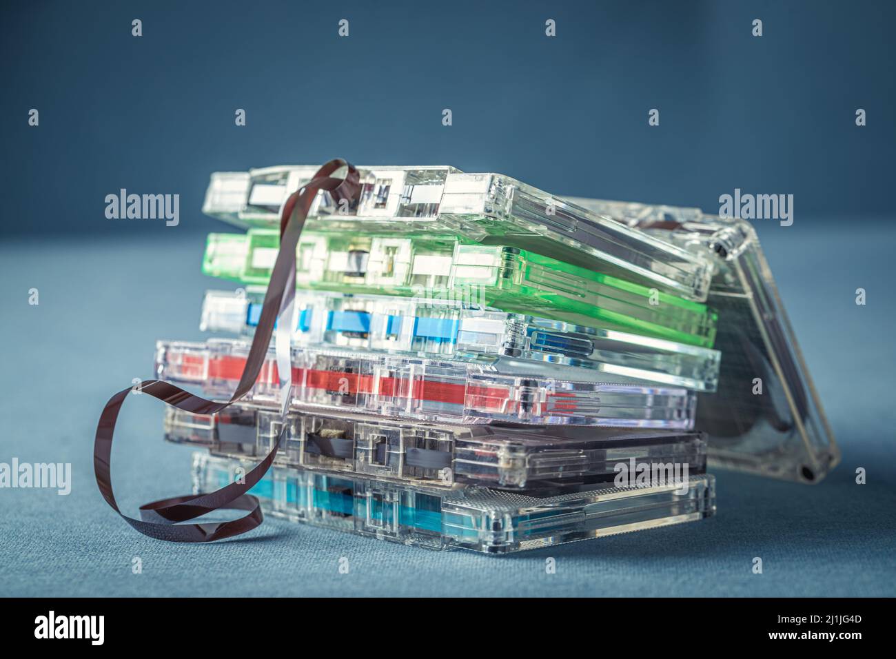 Pile of transparent cassette tapes and extracted tape on blue sofa ...