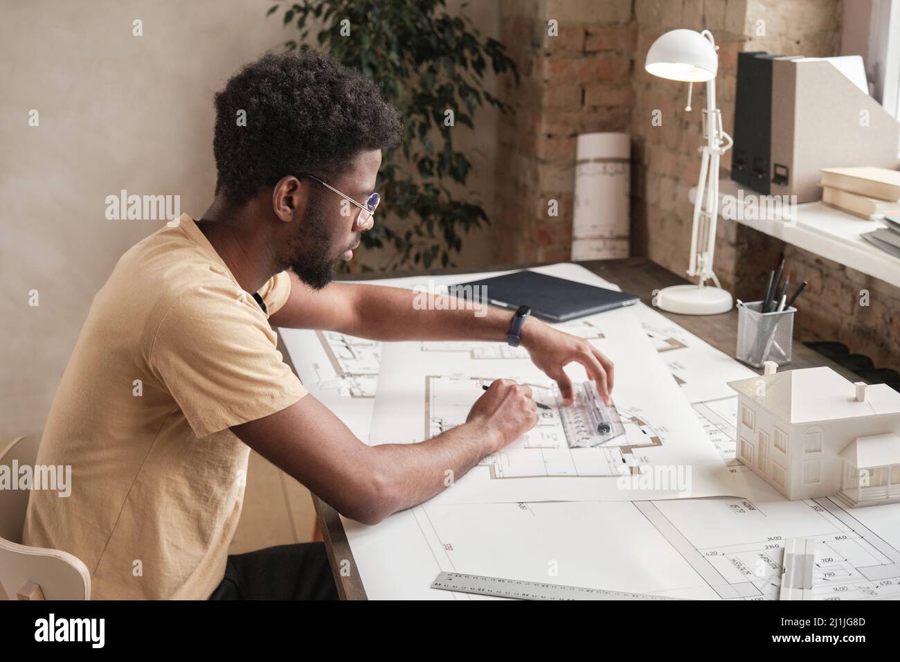 Concentrated young black architectural engineer with beard sitting at ...
