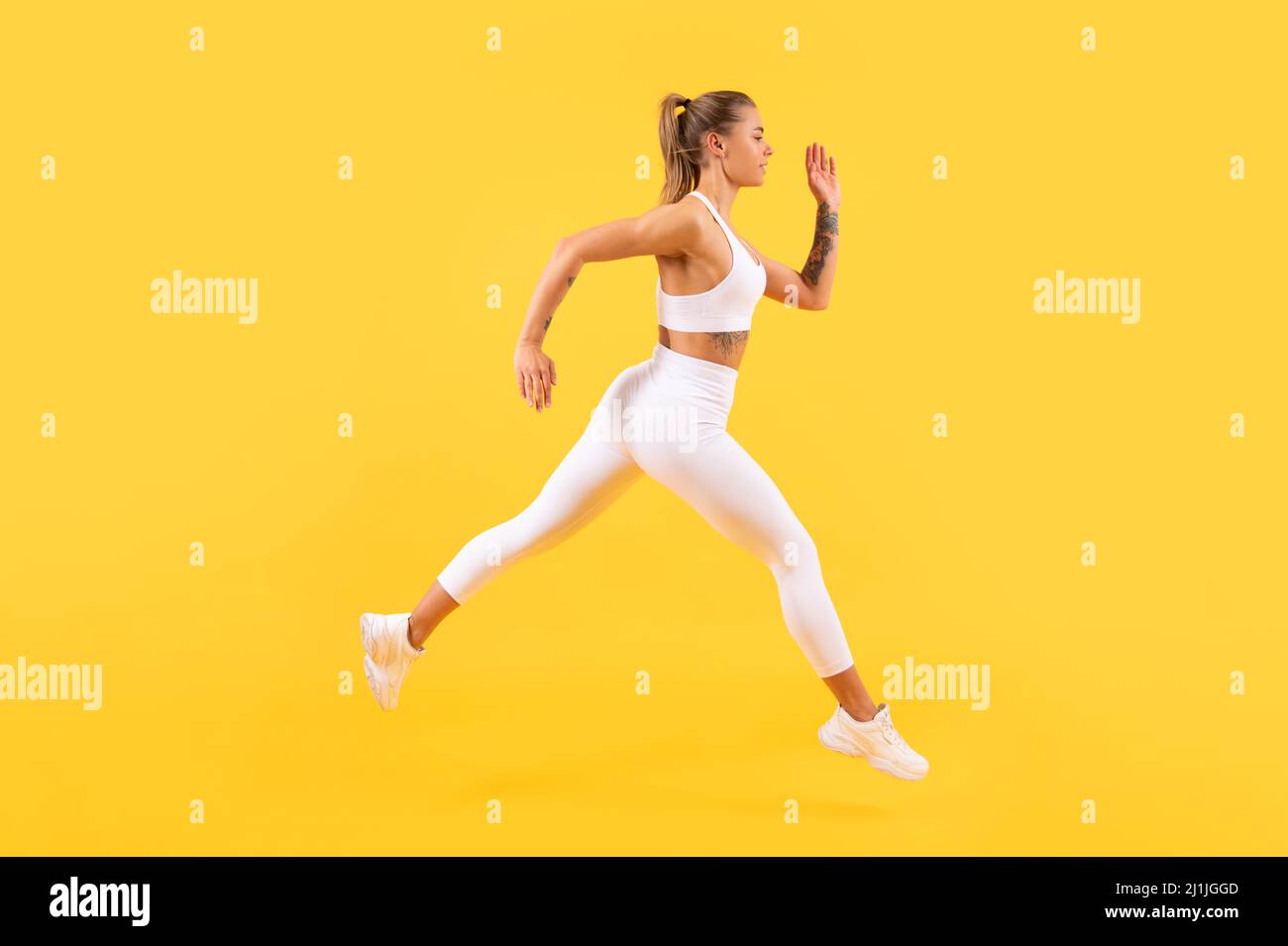 sport woman runner running on yellow background Stock Photo - Alamy