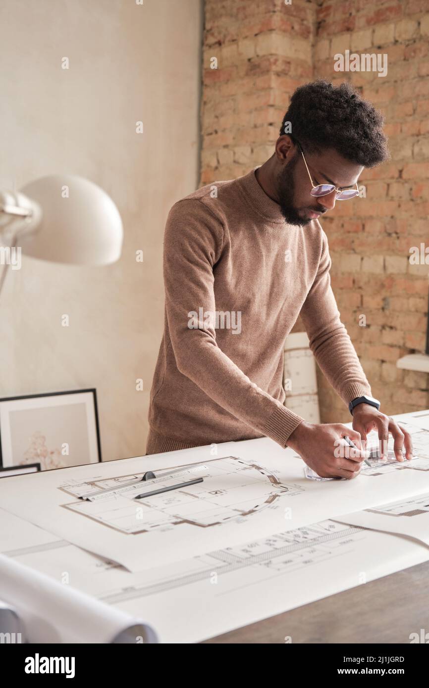 Concentrated black bearded architect with Afro hairstyle standing at ...