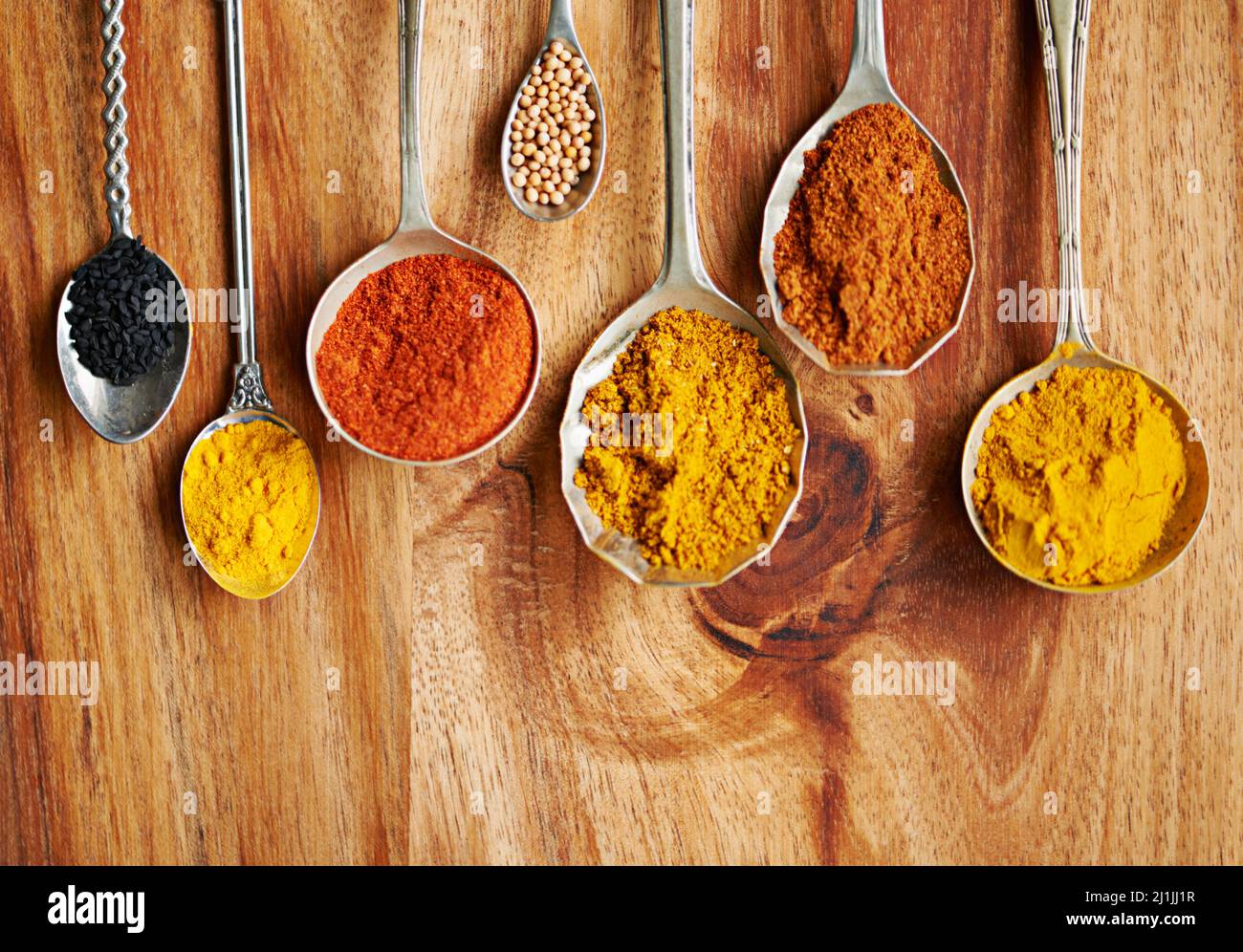 Adding flavor to your favorite dish. Cropped shot of spoons filled with ...
