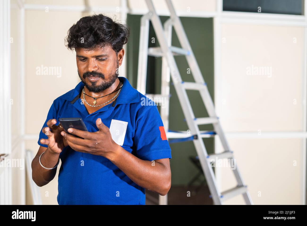 Aluminium partition worker busy using mobile phone at workplace ...